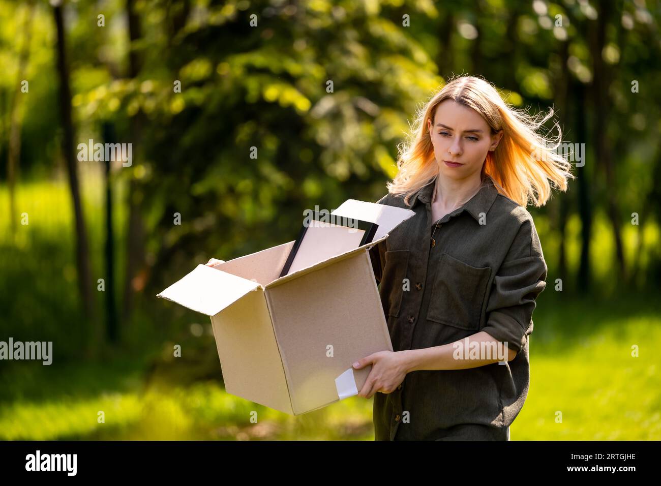 Cute blonde young woman carrying boxes in hands Stock Photo - Alamy