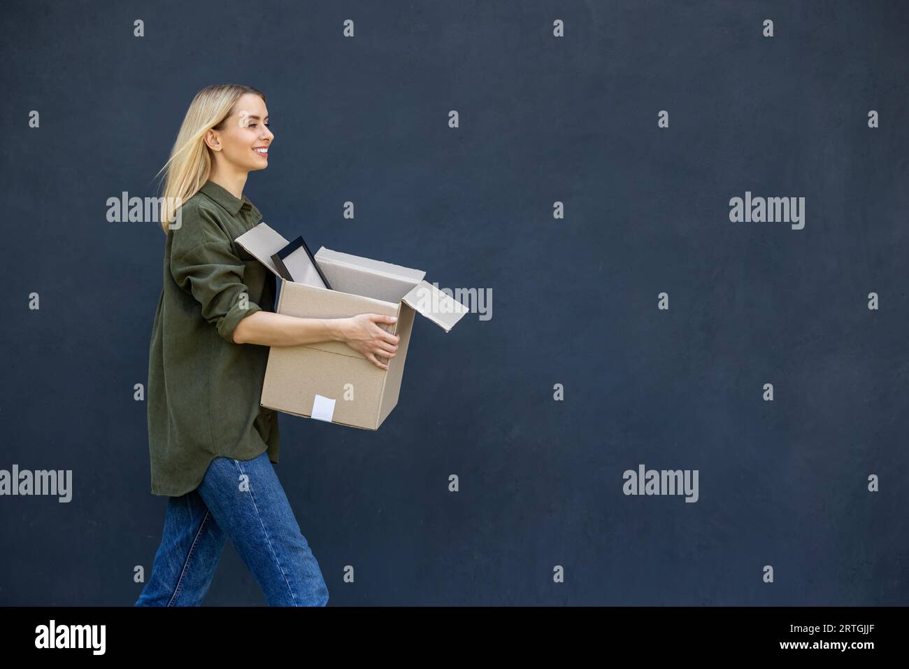 Cute blonde young woman carrying boxes in hands Stock Photo - Alamy
