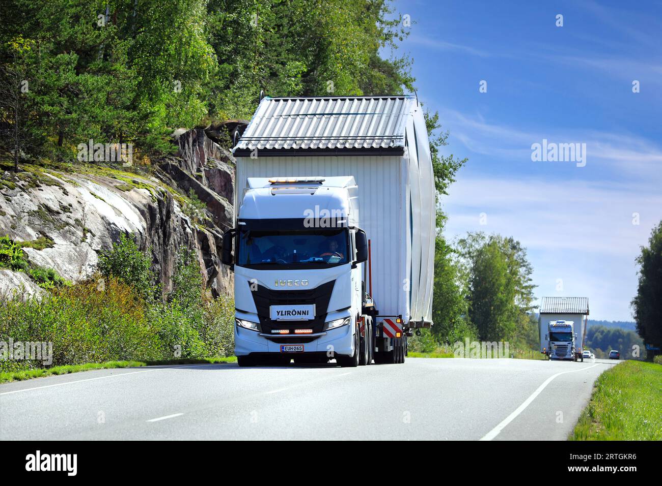 Two exceptional load transports hauling prefabricated cabins on highway ...
