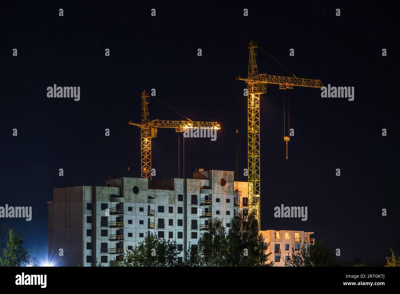 tower cranes working on construction at night Stock Photo - Alamy