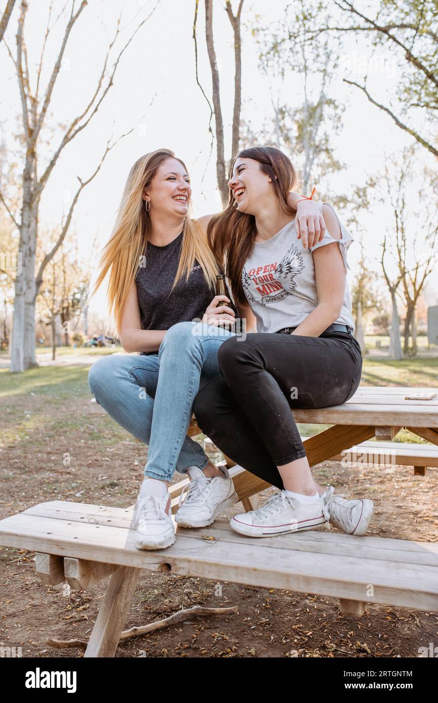 Girl friends hugging and laughing in park Stock Photo - Alamy