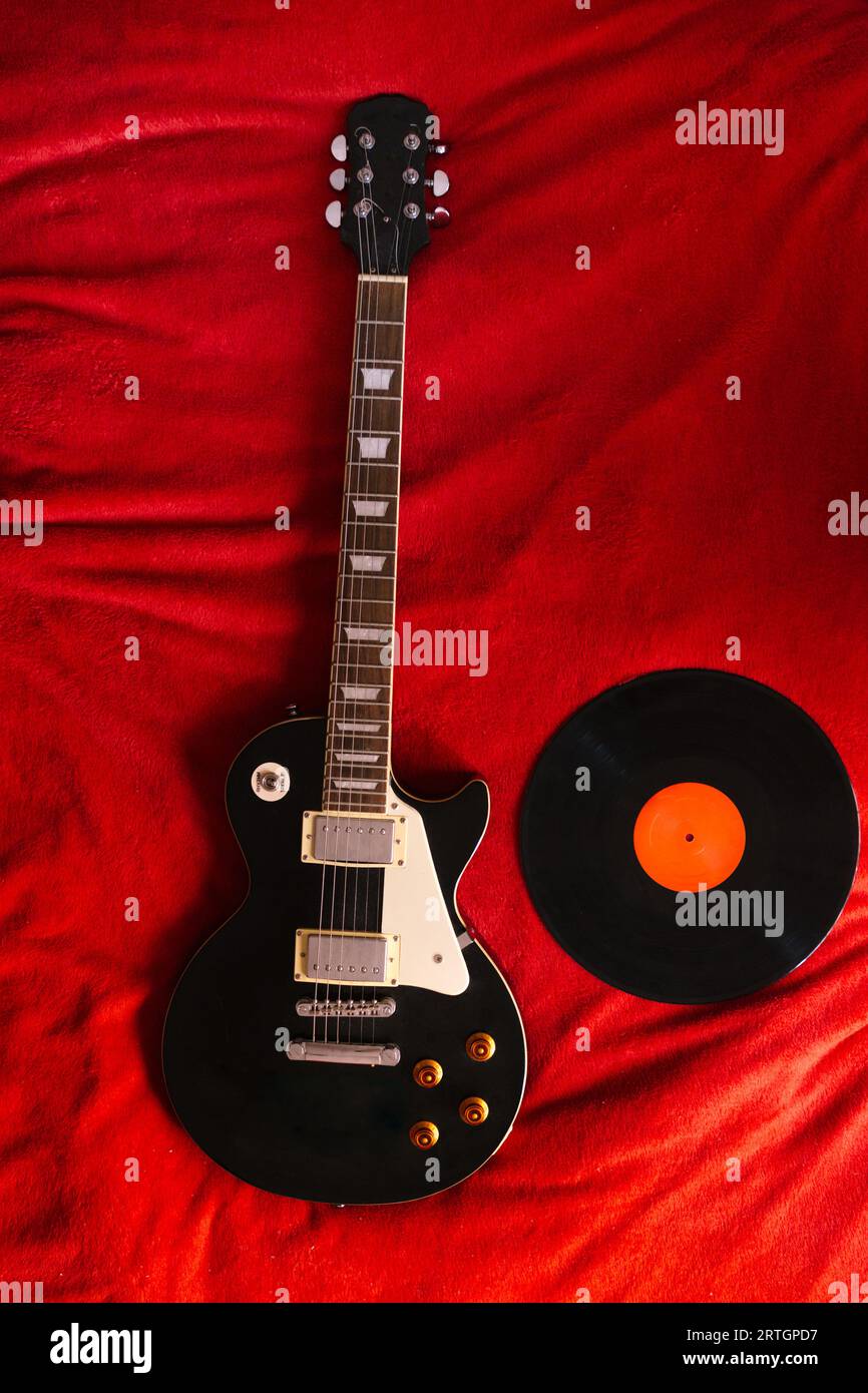 High angle of old fashioned vinyl disc and modern electric guitar ...