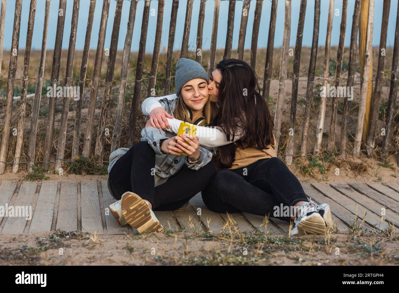 Full body of young lady with long dark hair in casual clothes sitting ...