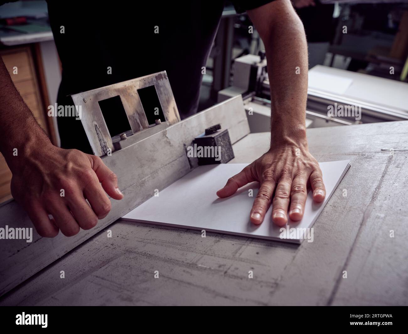 From above anonymous man using wooden workbench with paper sheets and ...