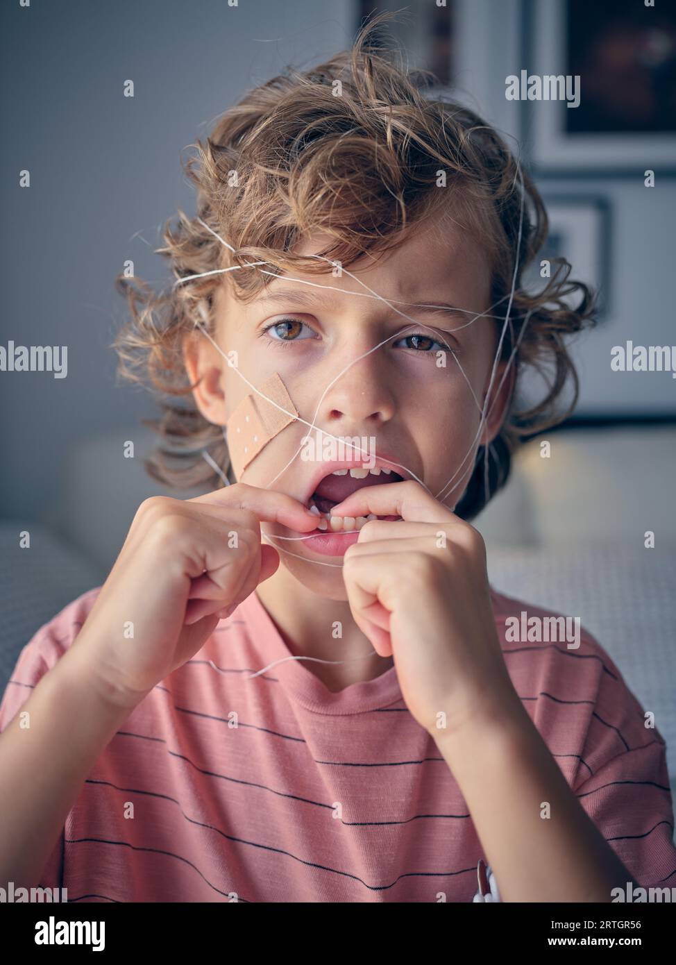 Brave boy in casual wear with thread on face looking away while ...