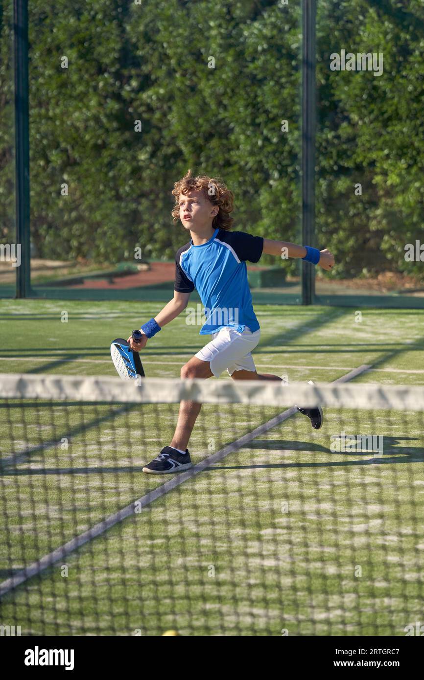 Full body of sportive boy in activewear playing padel game with special ...