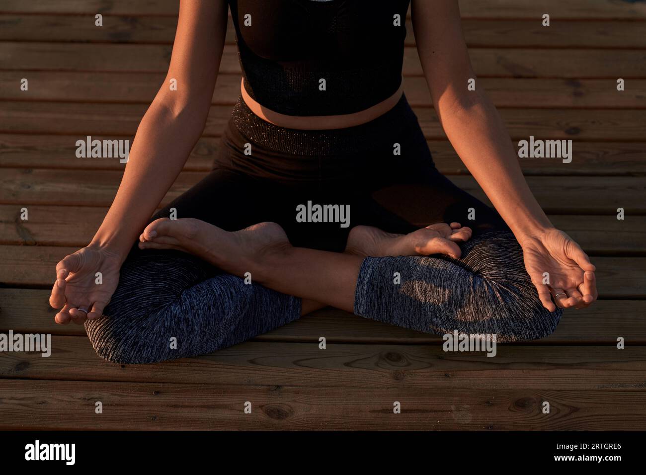 From above of crop anonymous barefoot female in sportswear sitting in ...