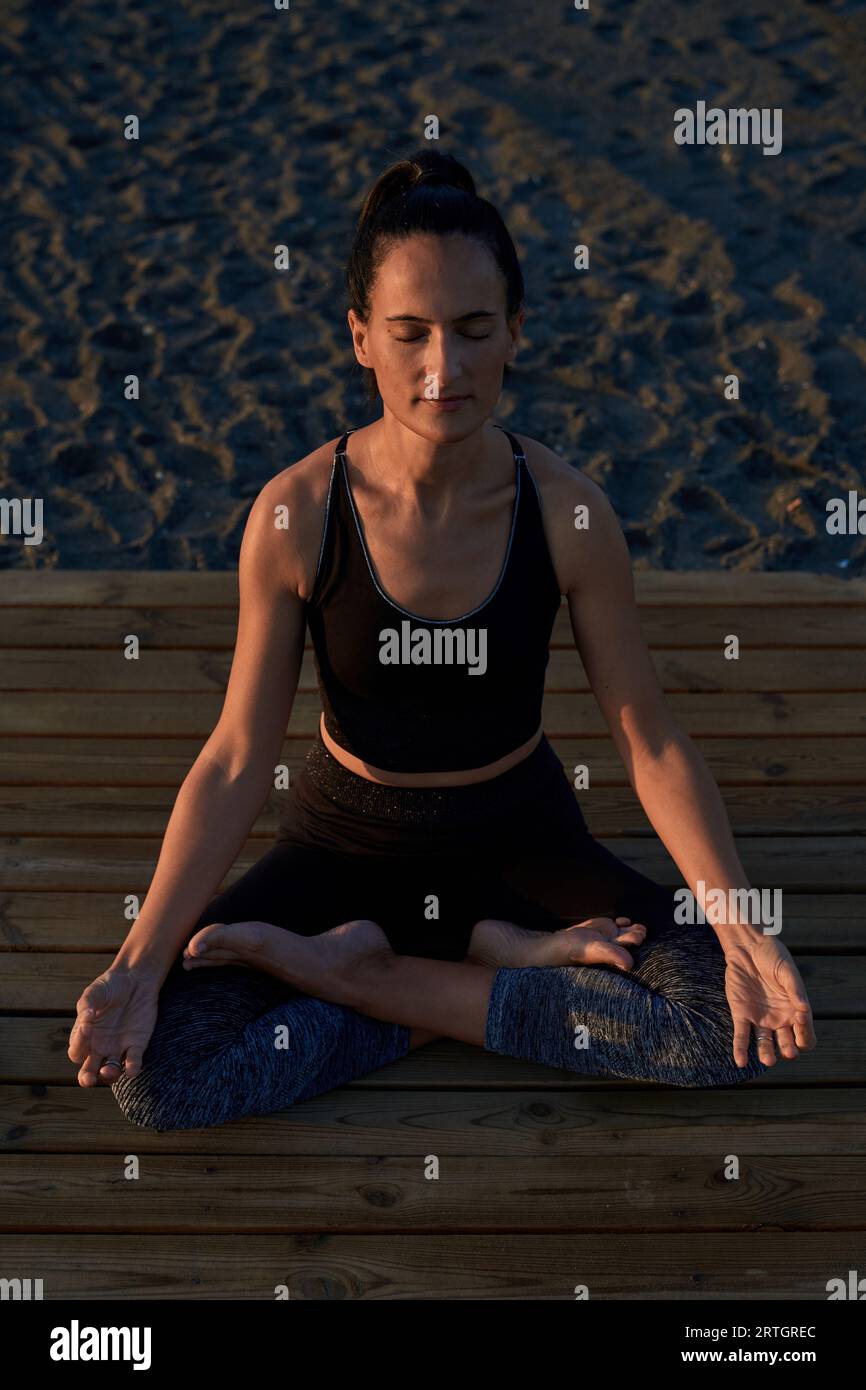 Woman meditating at seafront hi-res stock photography and images - Alamy