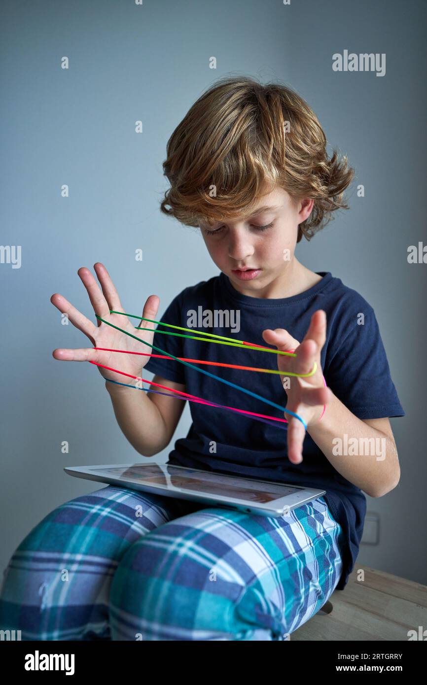 Concentrated preteen child in casual wear watching tutorial video on ...