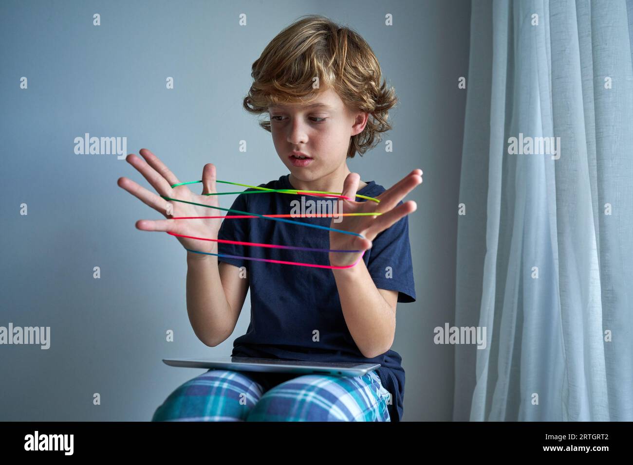 Focused child in casual wear with tablet making figure with colorful ...