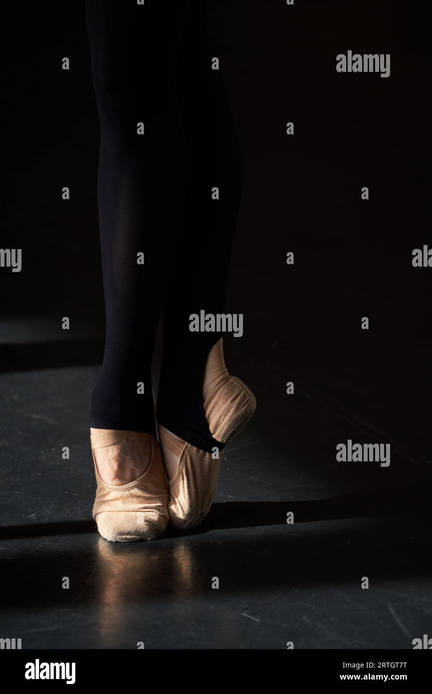 Feet of a professional ballet dancer in a warm-up before rehearsal ...
