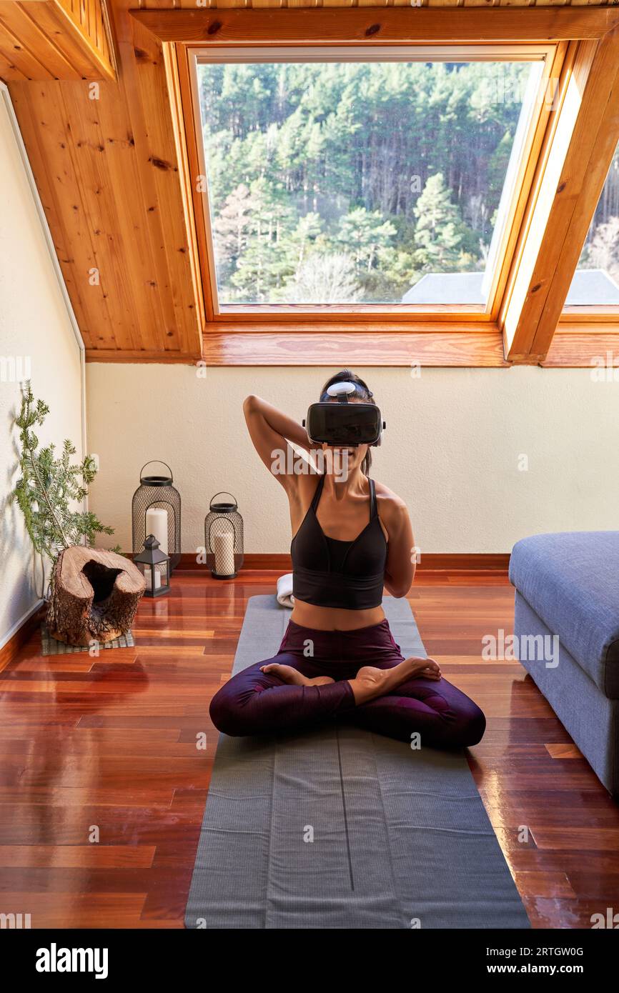 Full body of barefoot female in virtual reality glasses and sitting in ...