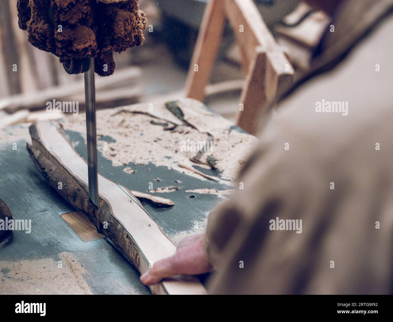 Crop blurred unrecognizable male carpenter cutting wooden detail with ...