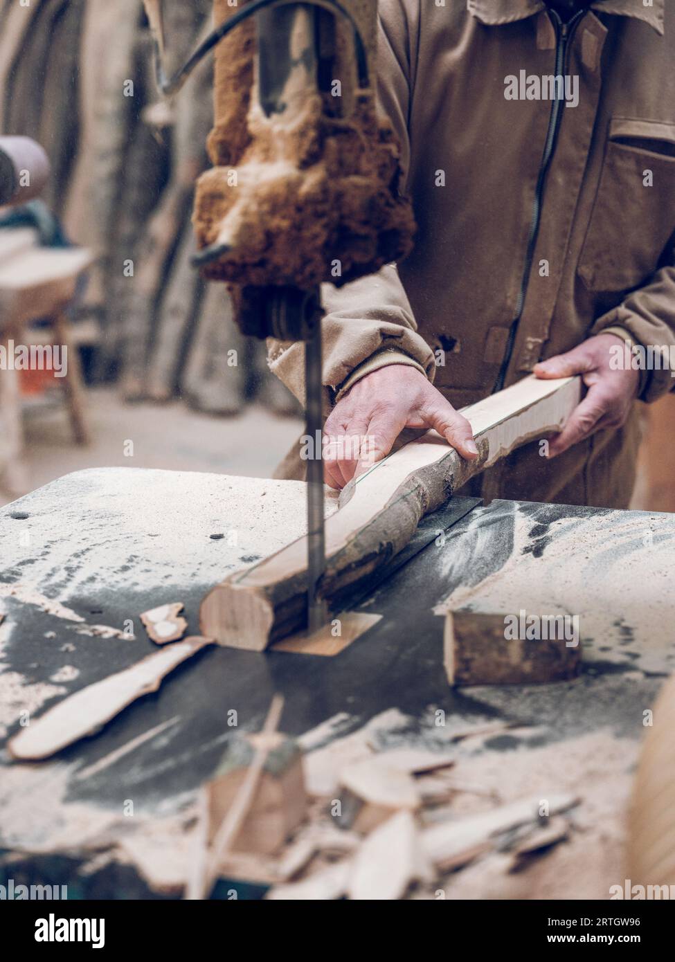 Crop unrecognizable male carpenter cutting wooden detail with scroll ...