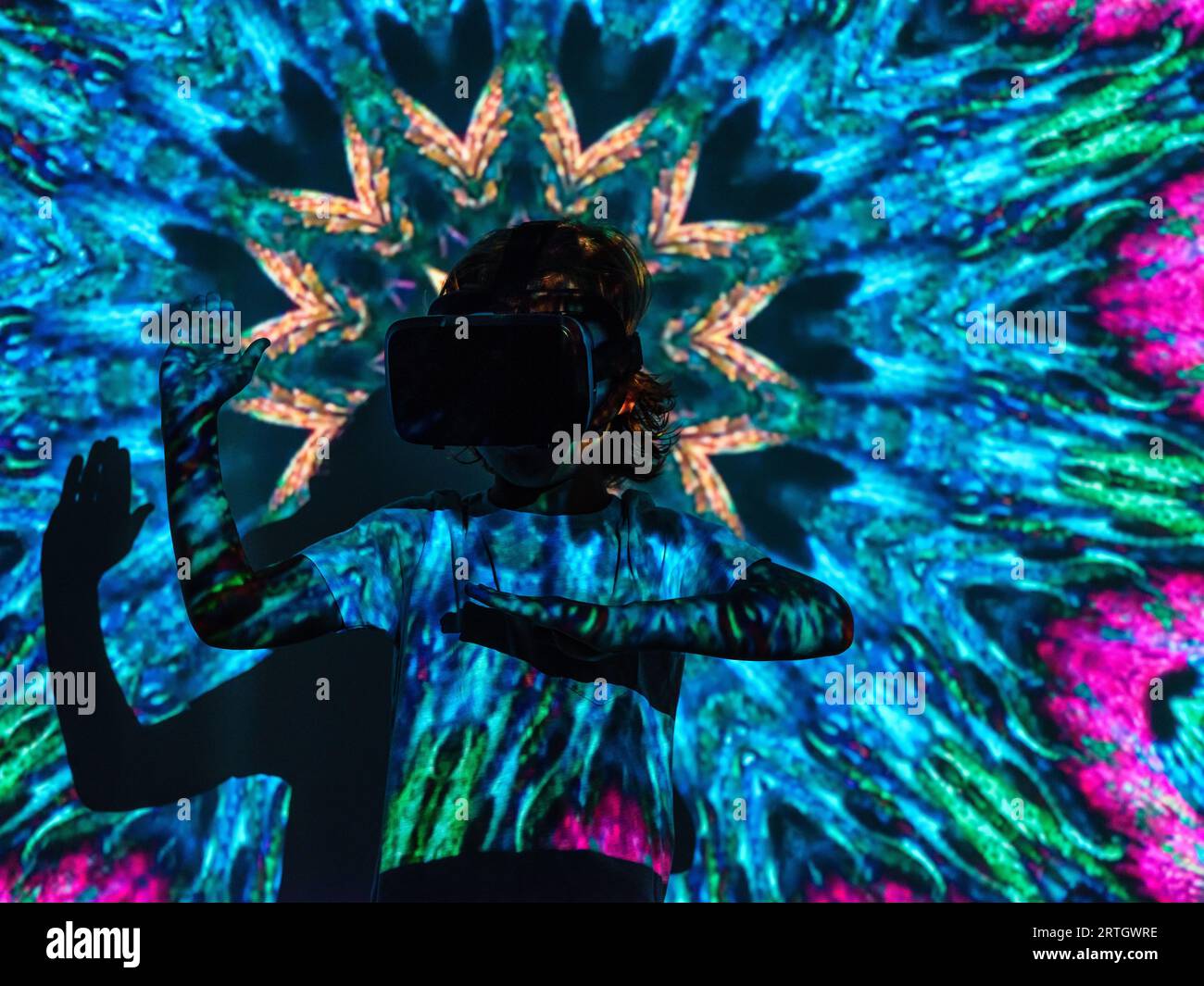 Anonymous child in VR headset playing in virtual reality while standing ...