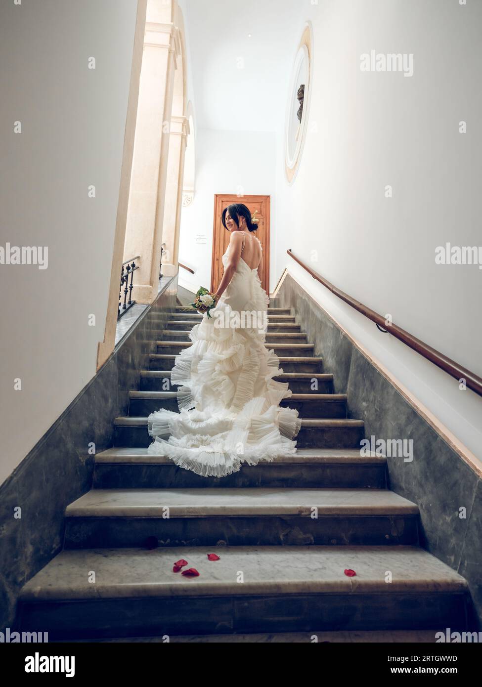 From below of back view of full body bride in elegant white wedding ...