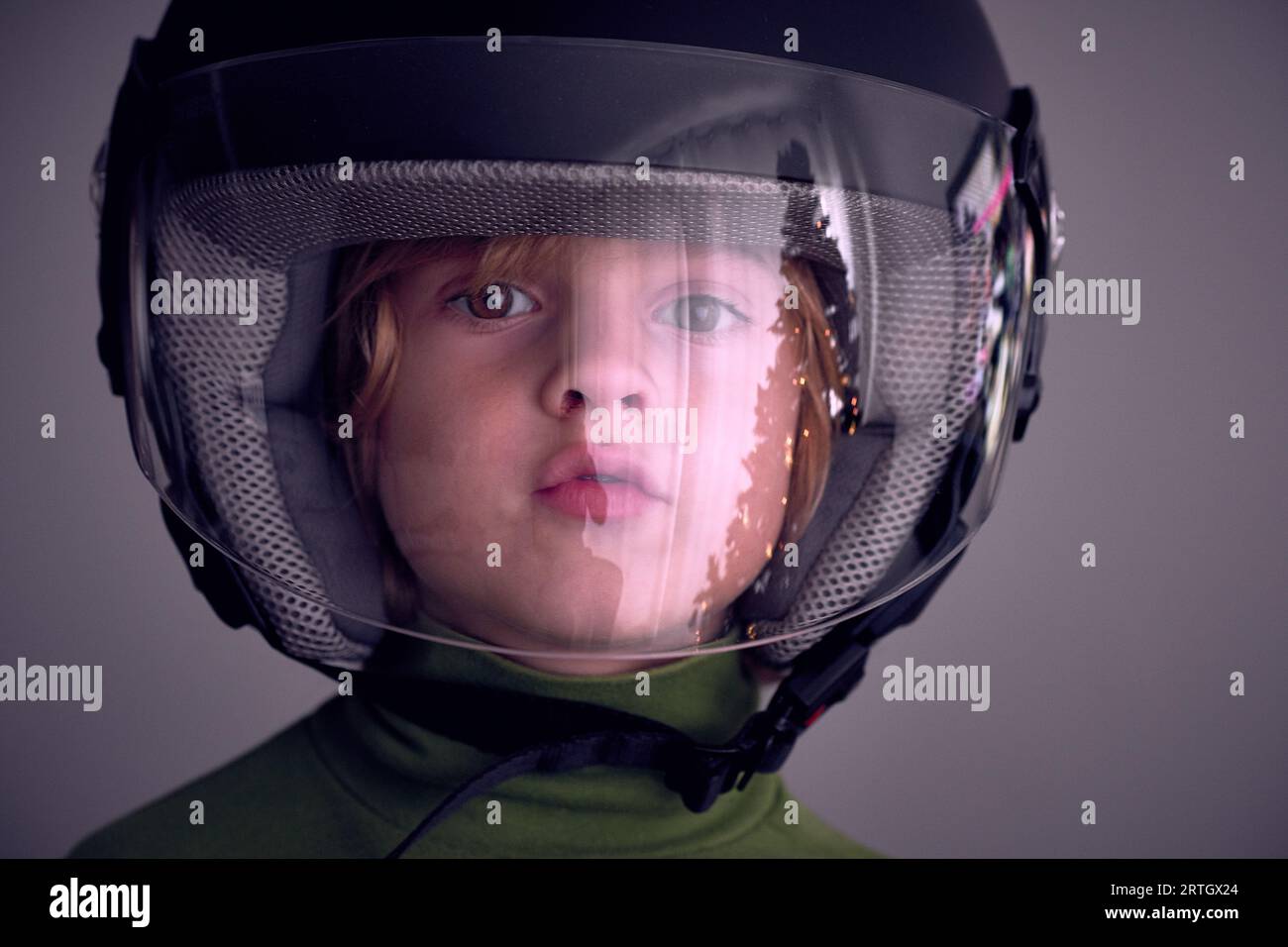 Little kid with brown eyes wearing black safety helmet with transparent ...