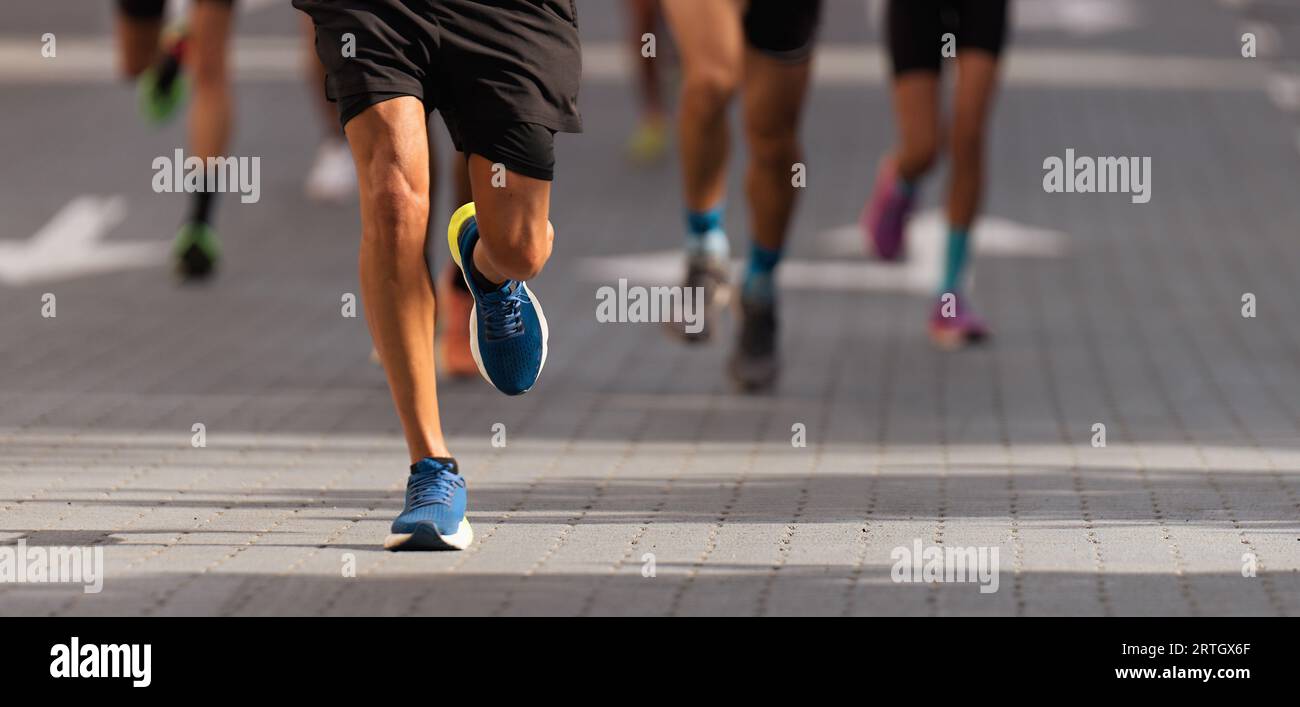 Marathon runners running on city road, large group of runners Stock ...