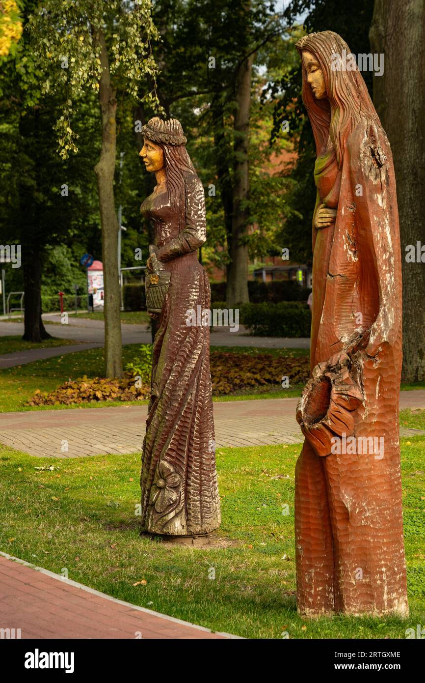 wooden statues of two women in a public park in Ostroda in Poland Stock ...
