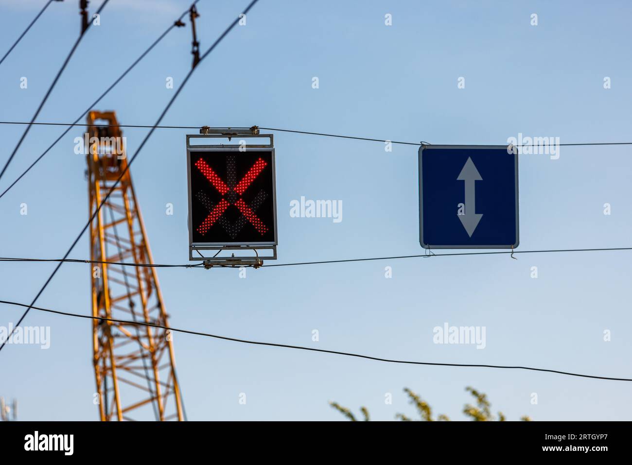 red X light and reversible lane sign above road wtih blurry yellow ...