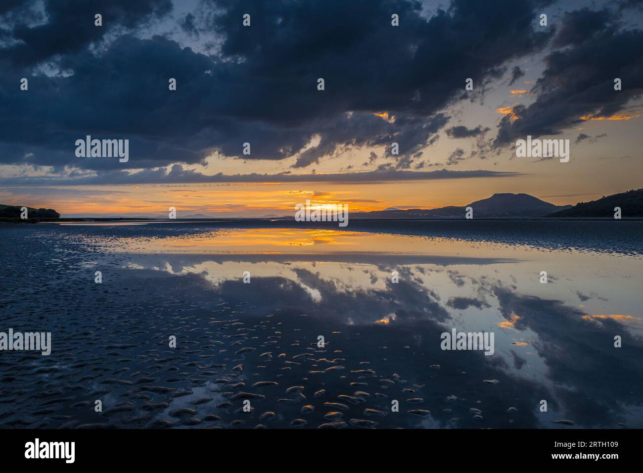 Sunset at Traeth Bach with blue sky and calm sea Stock Photo - Alamy