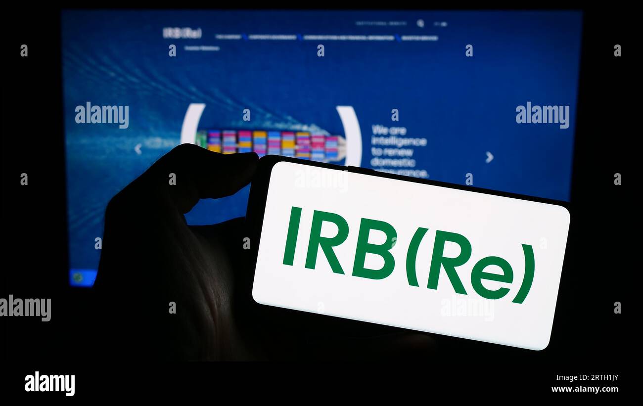 Person holding smartphone with logo of Brazilian reinsurance company ...