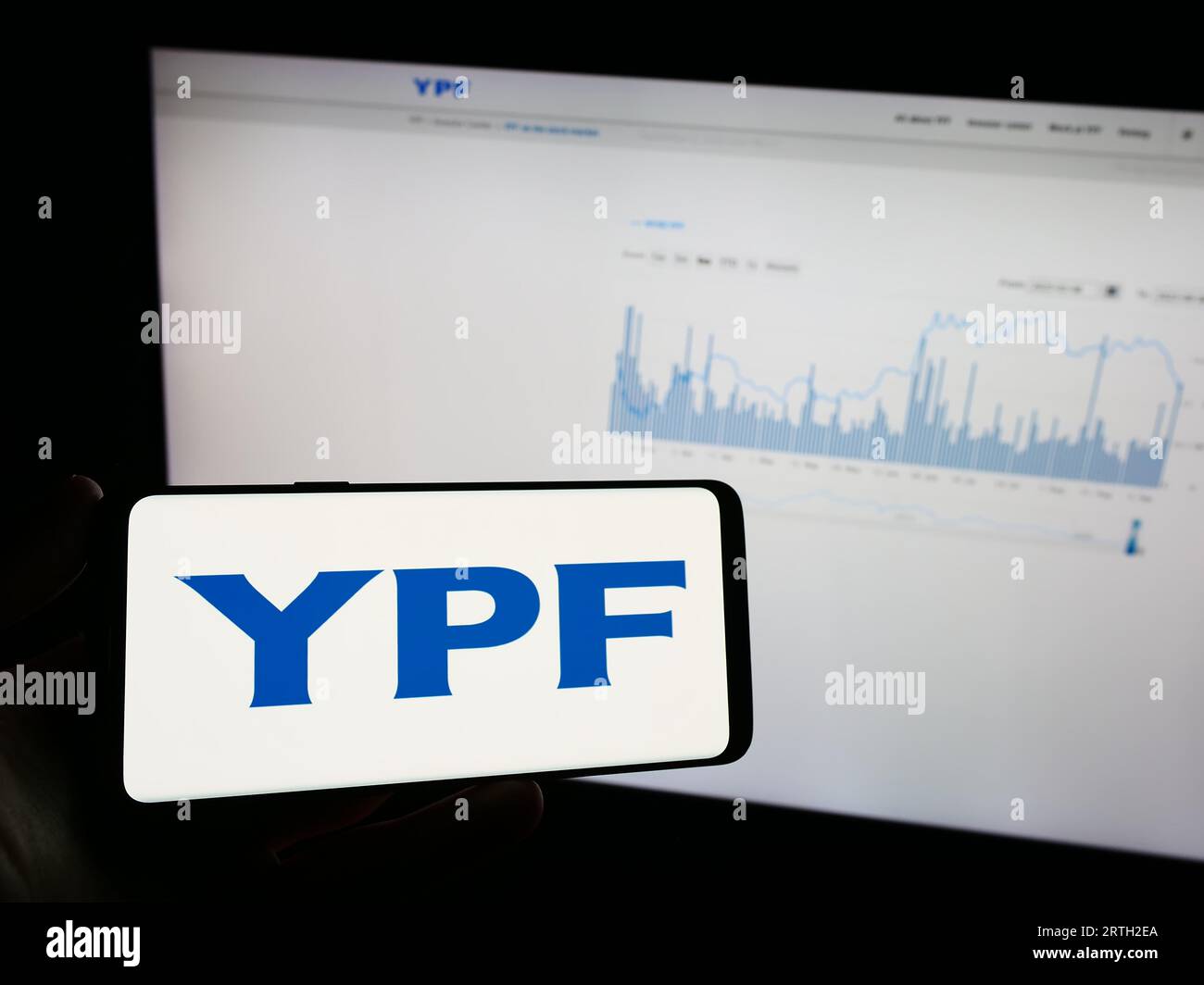 Person holding mobile phone with logo of Argentinian petroleum company ...