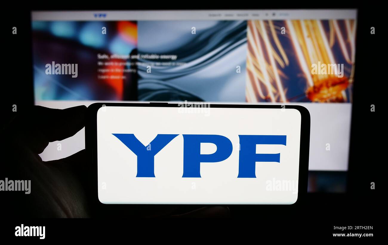 Person holding smartphone with logo of Argentinian petroleum company ...