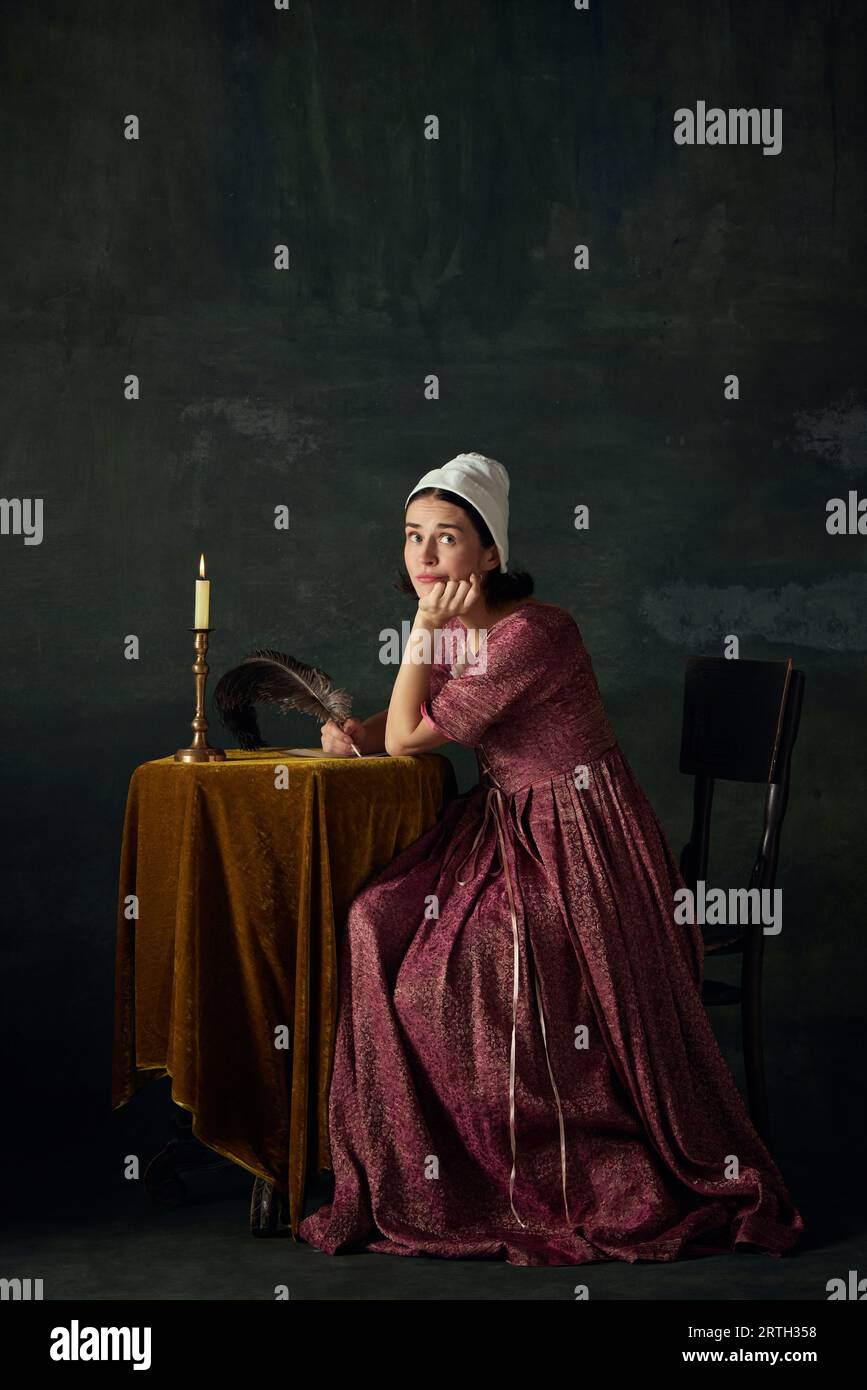 Pretty, dreaming young woman in image of renaissance maid sitting at ...