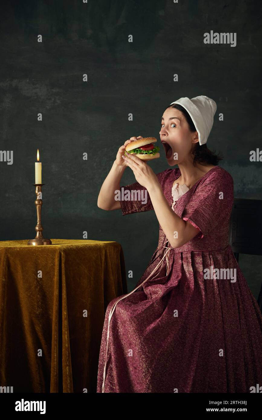 Junk food lover. Medieval woman in historical costume in image of ...