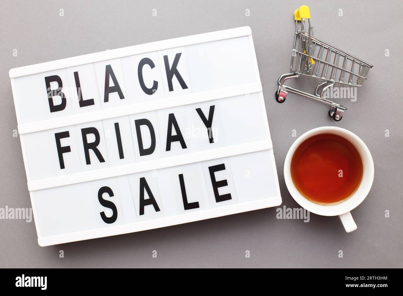 friday sale announcement on a writing box on grey background with cup ...