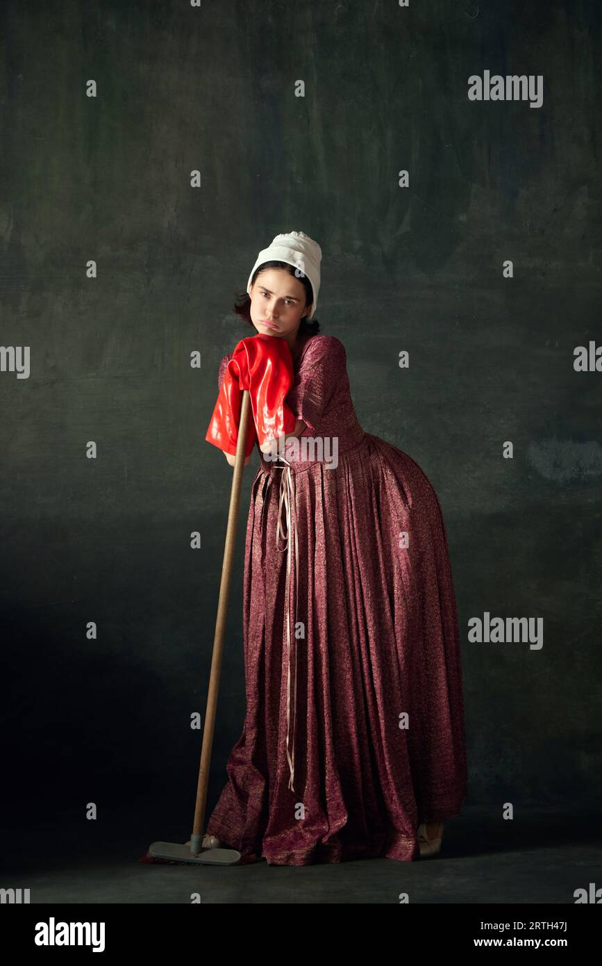 Bored and tired. Beautiful woman, medieval maid in dress standing ...