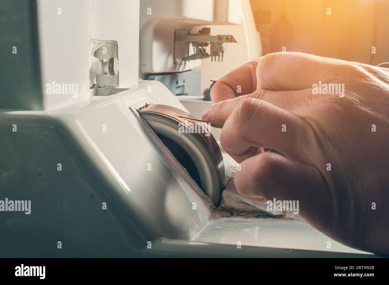 A man sharpens a metal needle on a grinding wheel. Close-up of master ...