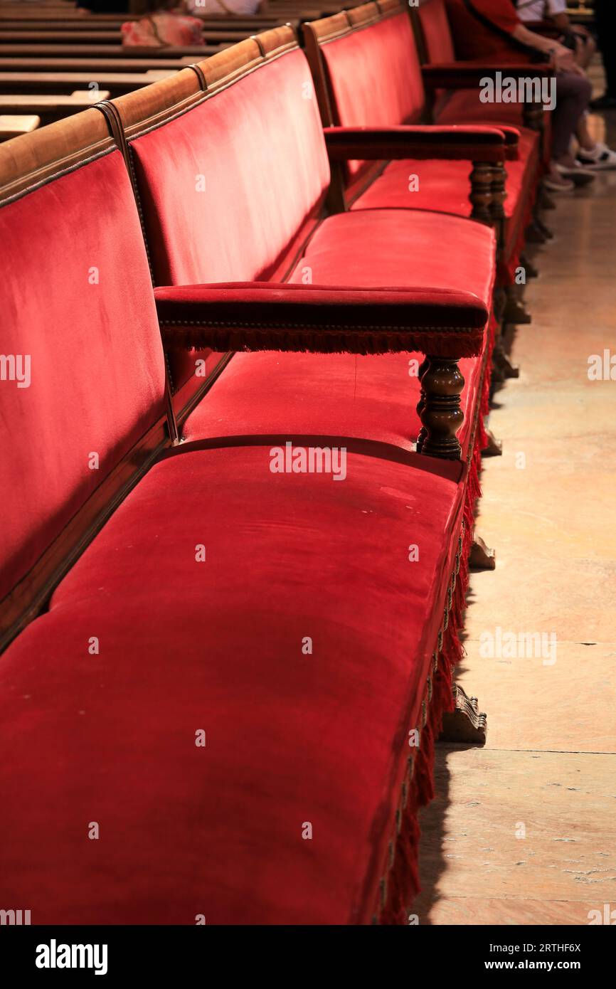 Colorful red velvet covered seats inside a chuch in Spain Stock Photo ...