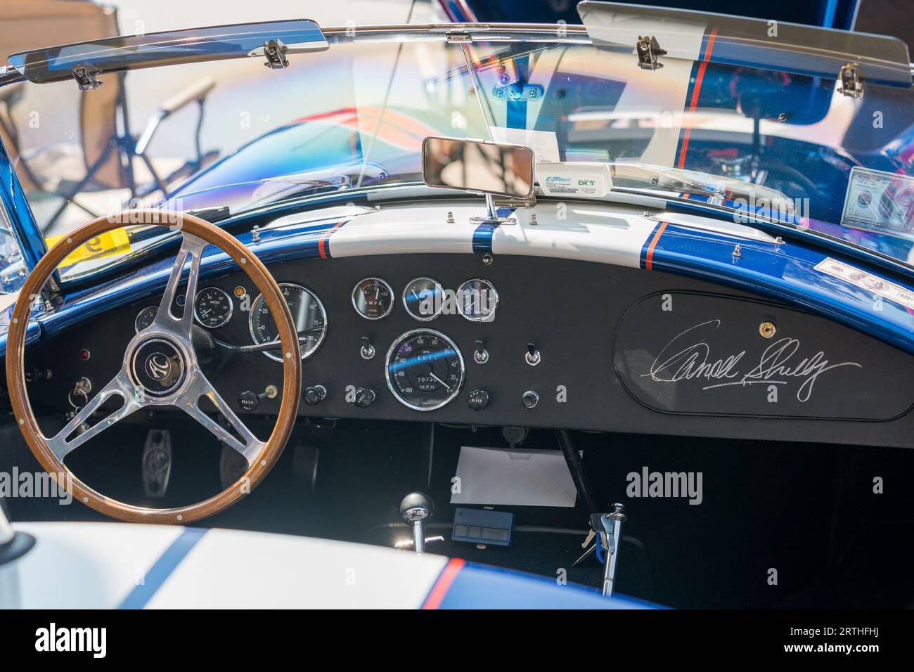 A close-up of a bright blue AC Cobra car with a racing stripe and an ...