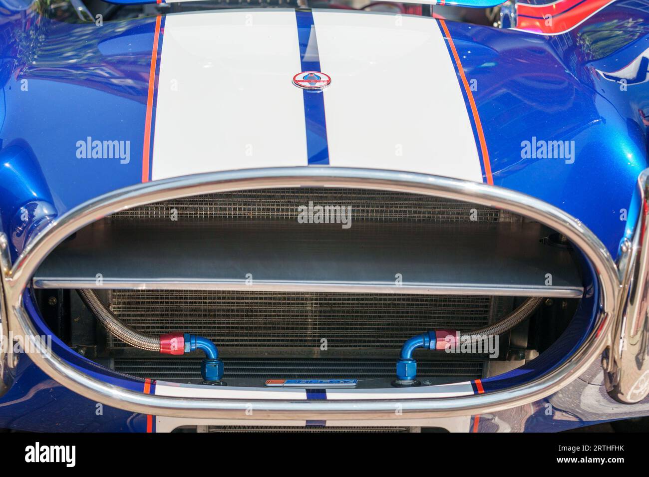 A close-up of a bright blue AC Cobra car with a racing stripe and an ...
