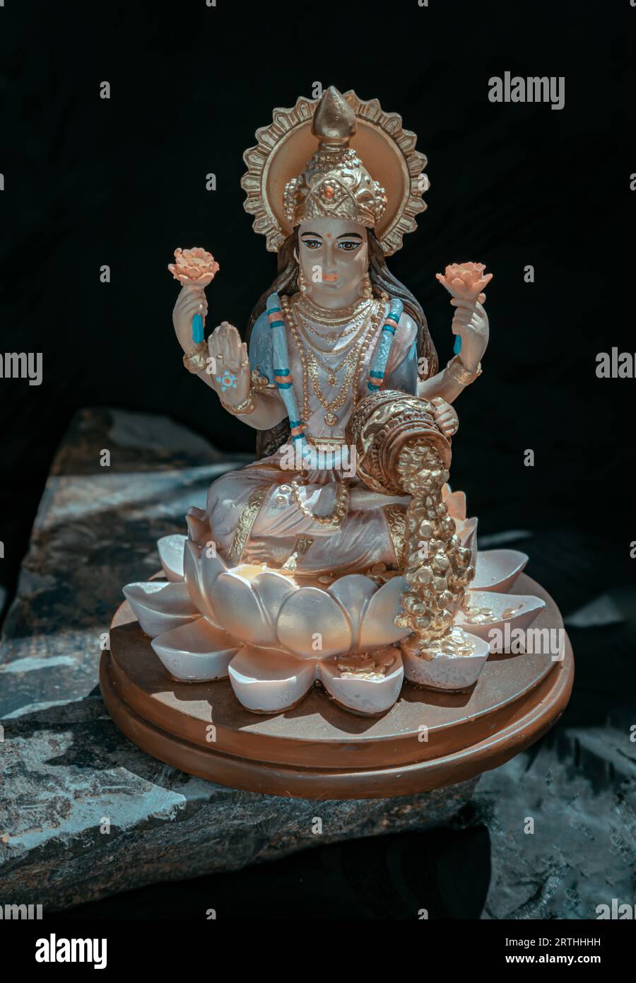 Hindu cosmos Maha laxshmi statue decorated with Flower Garland on black ...