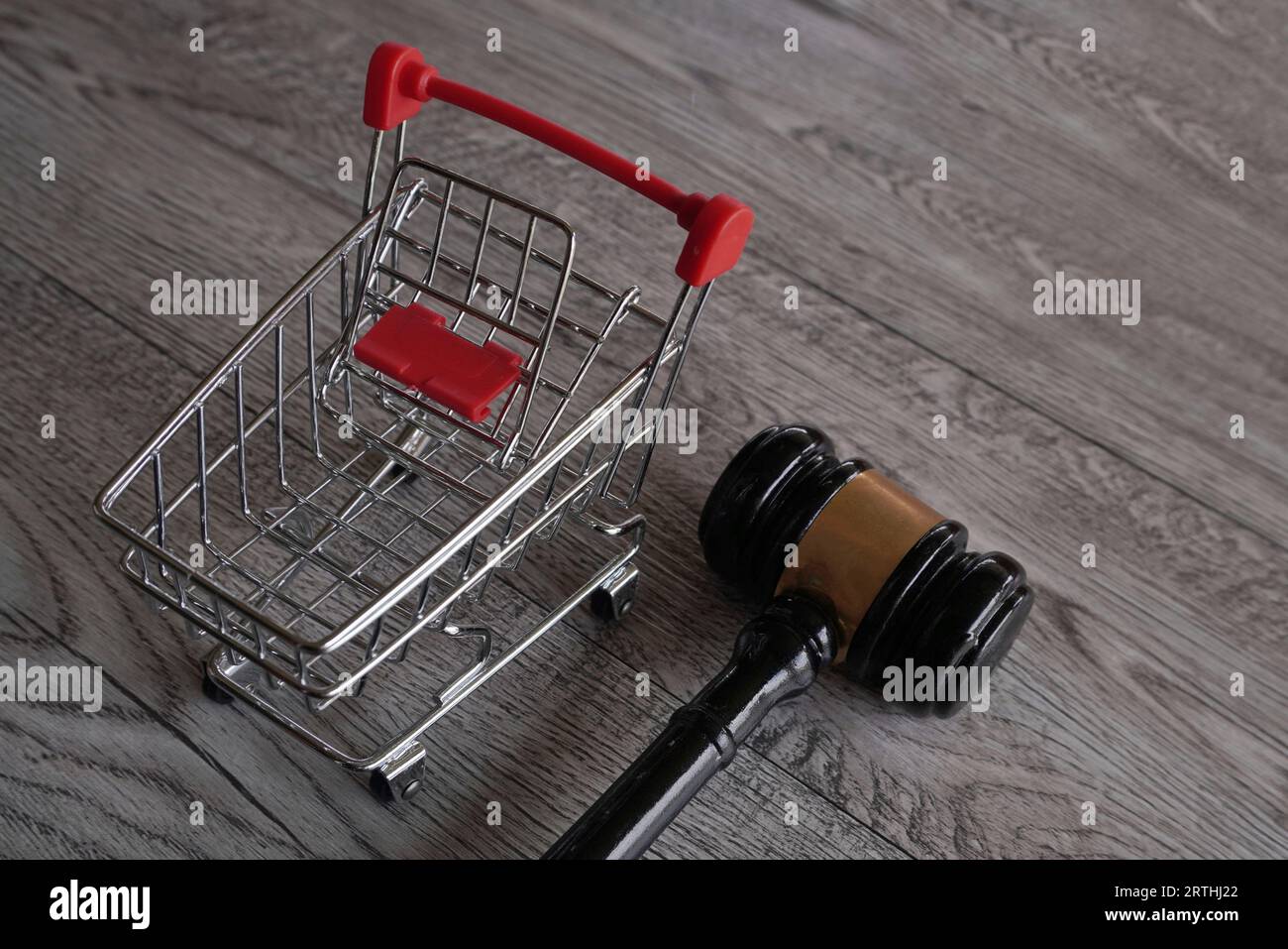 Closeup image of judge gavel and shopping trolley on table. Consumer ...