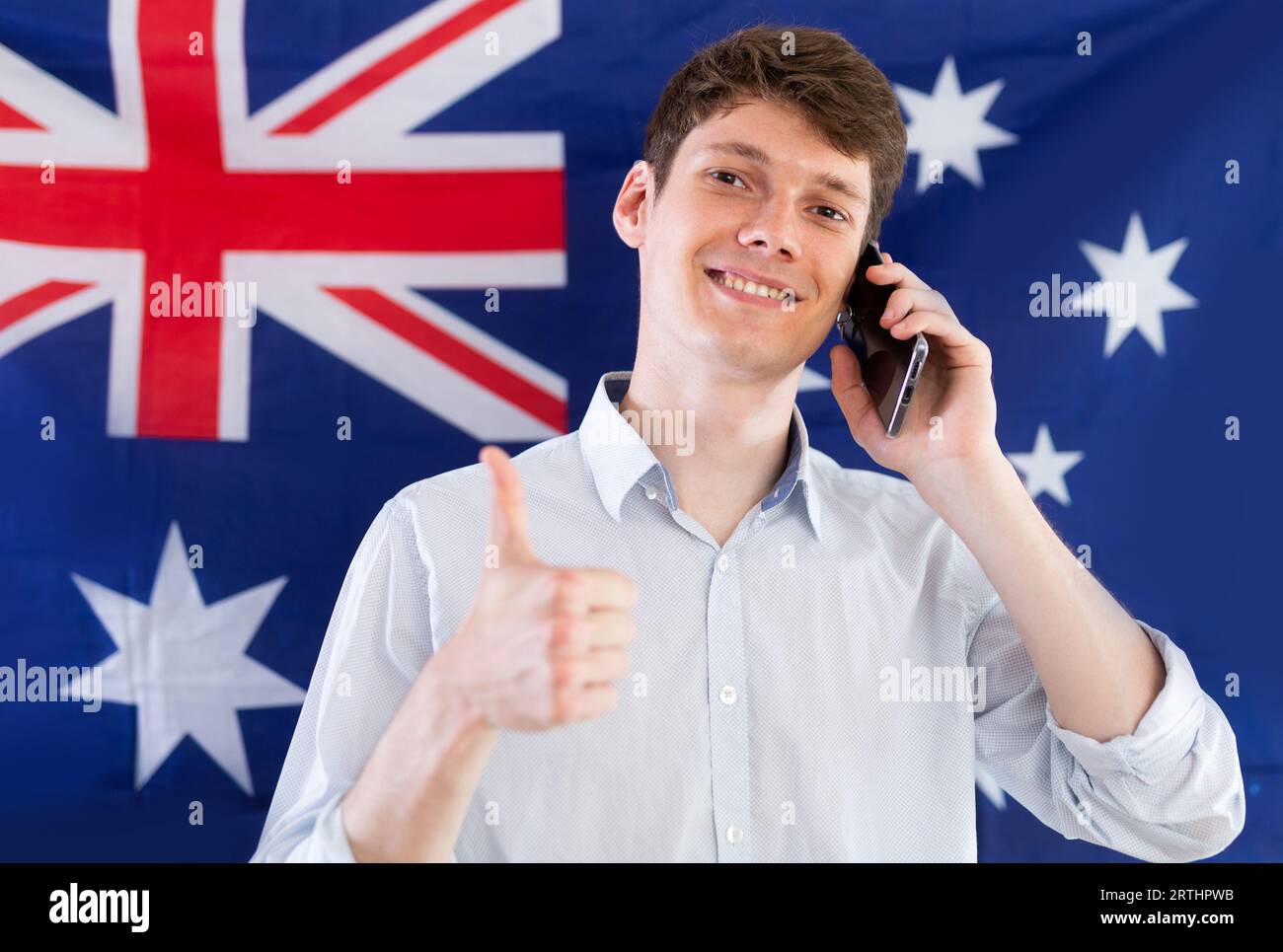 Young guy talking on phone in front of Australian flag Stock Photo - Alamy
