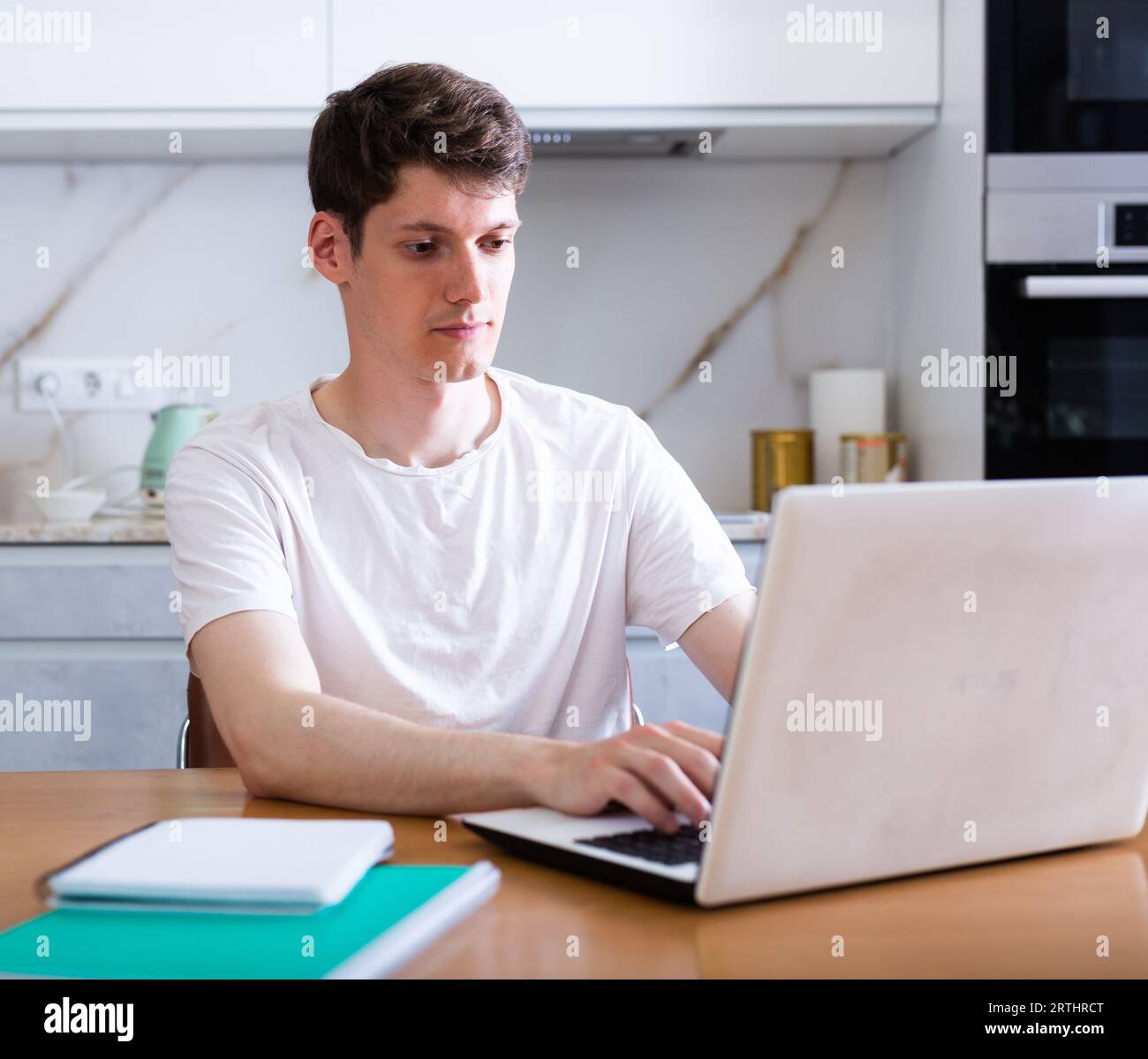 Young guy studying at home with laptop Stock Photo - Alamy