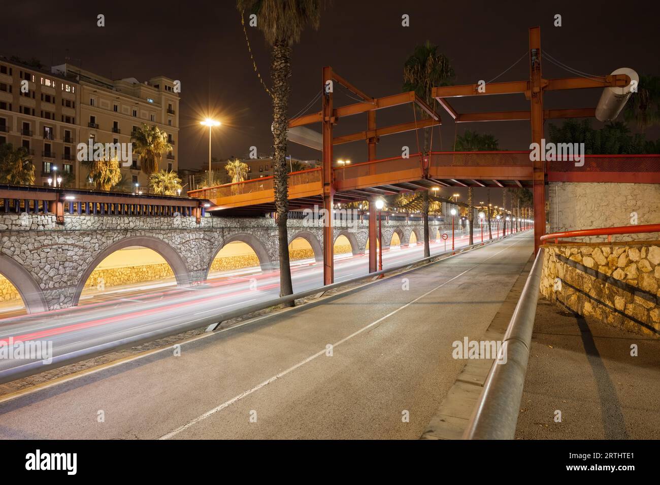 Spain, Barcelona, Ronda Litoral freeway at night with footbridge ...