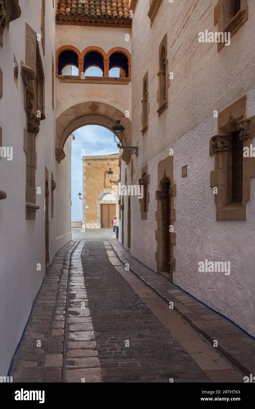 Sitges Old Town in Catalonia, Spain, narrow street with arched covered ...