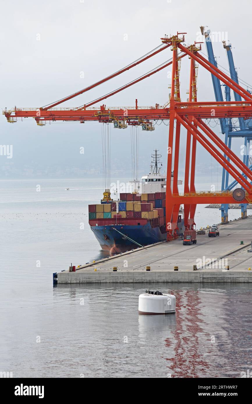 Container ship docked at port with gantry cranes loading containers hi ...