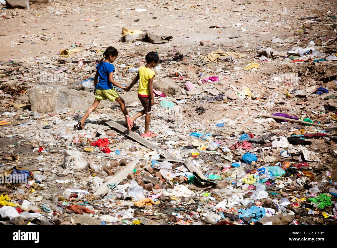 Children play in piles of trash in a slum in Airoli, Mumbai, INdia ...