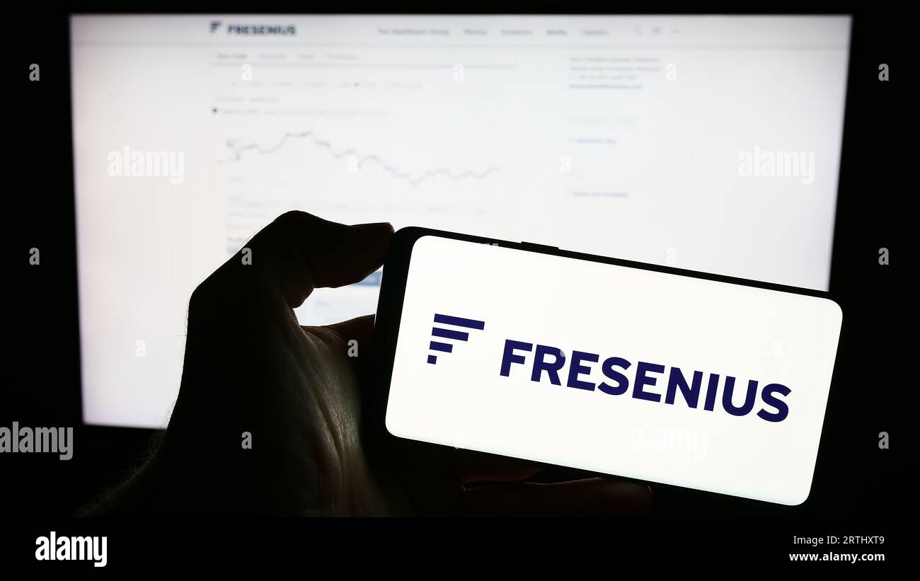Person holding mobile phone with logo of German healthcare company ...