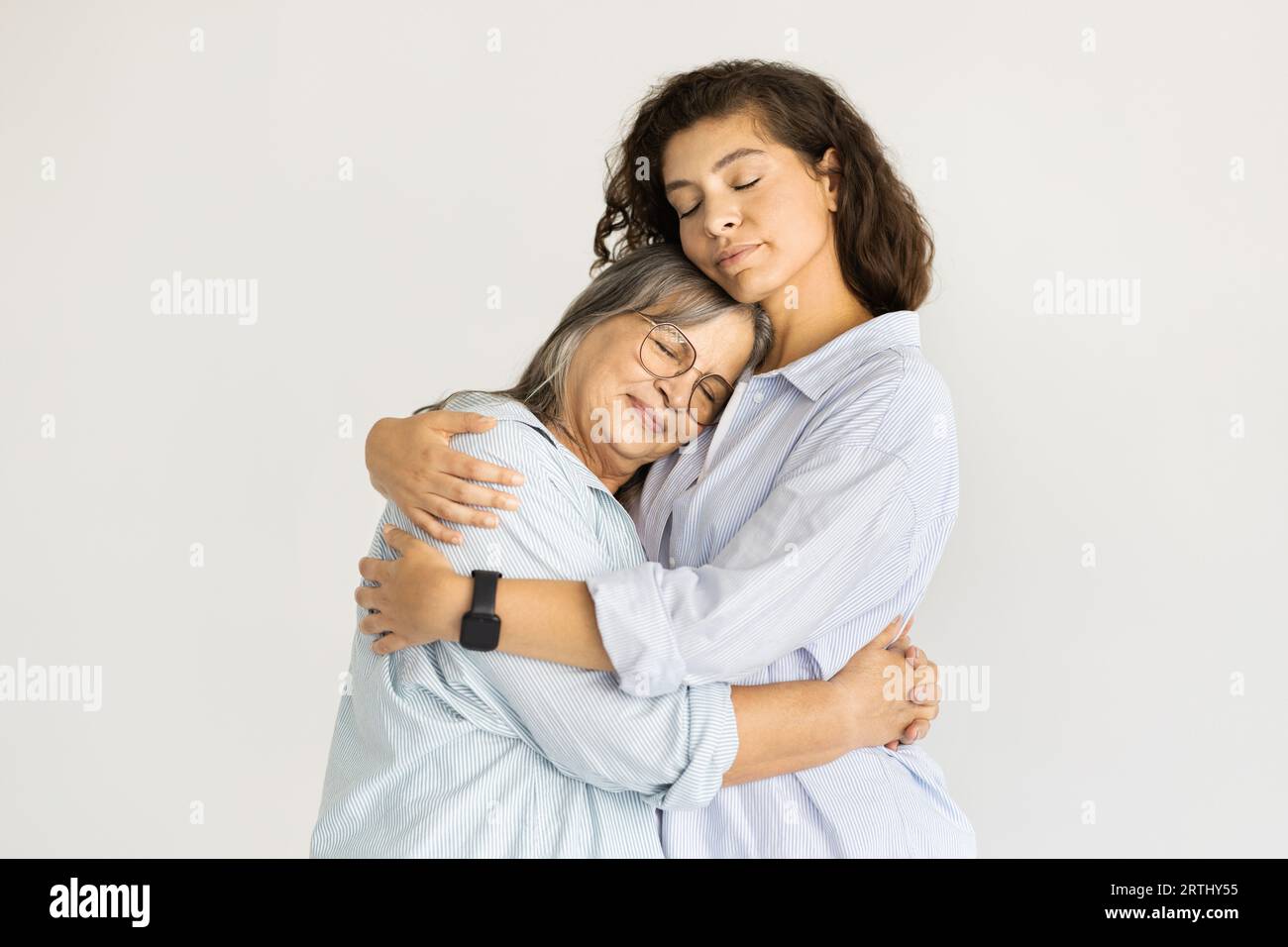 Cheerful caucasian mature lady hugging old mom with closed eyes enjoy ...