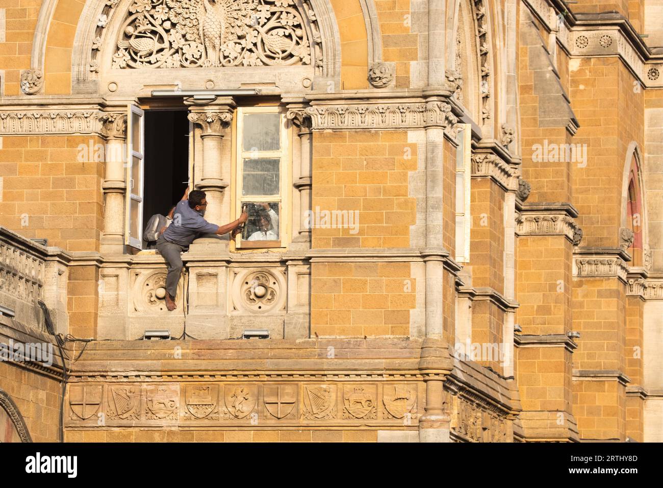 MUMBAI, INDIA, November 9 2017: A worker fixes a window at Chhatrapati ...