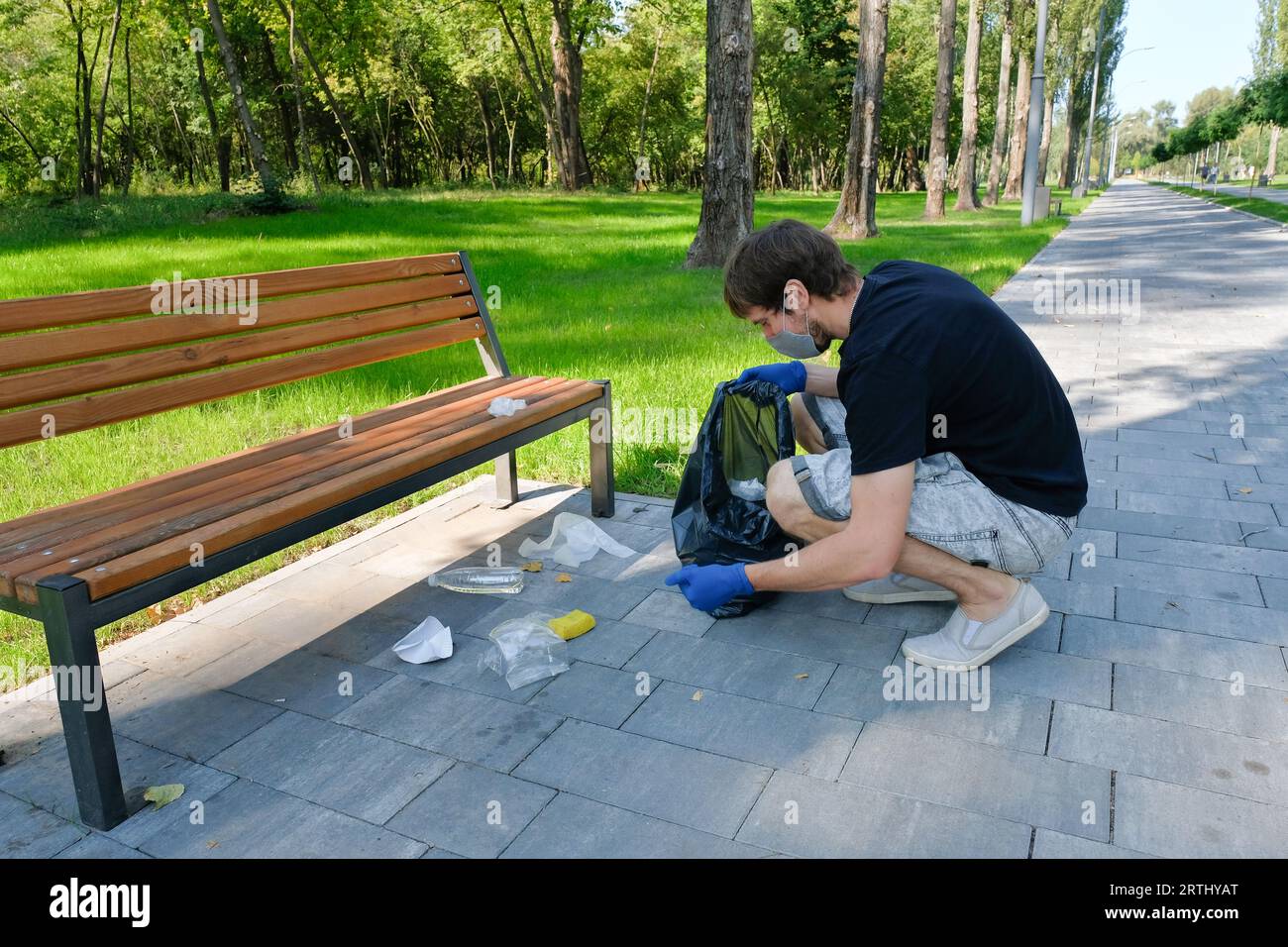 A volunteer removes rubbish in public parks. Pollution of nature ...