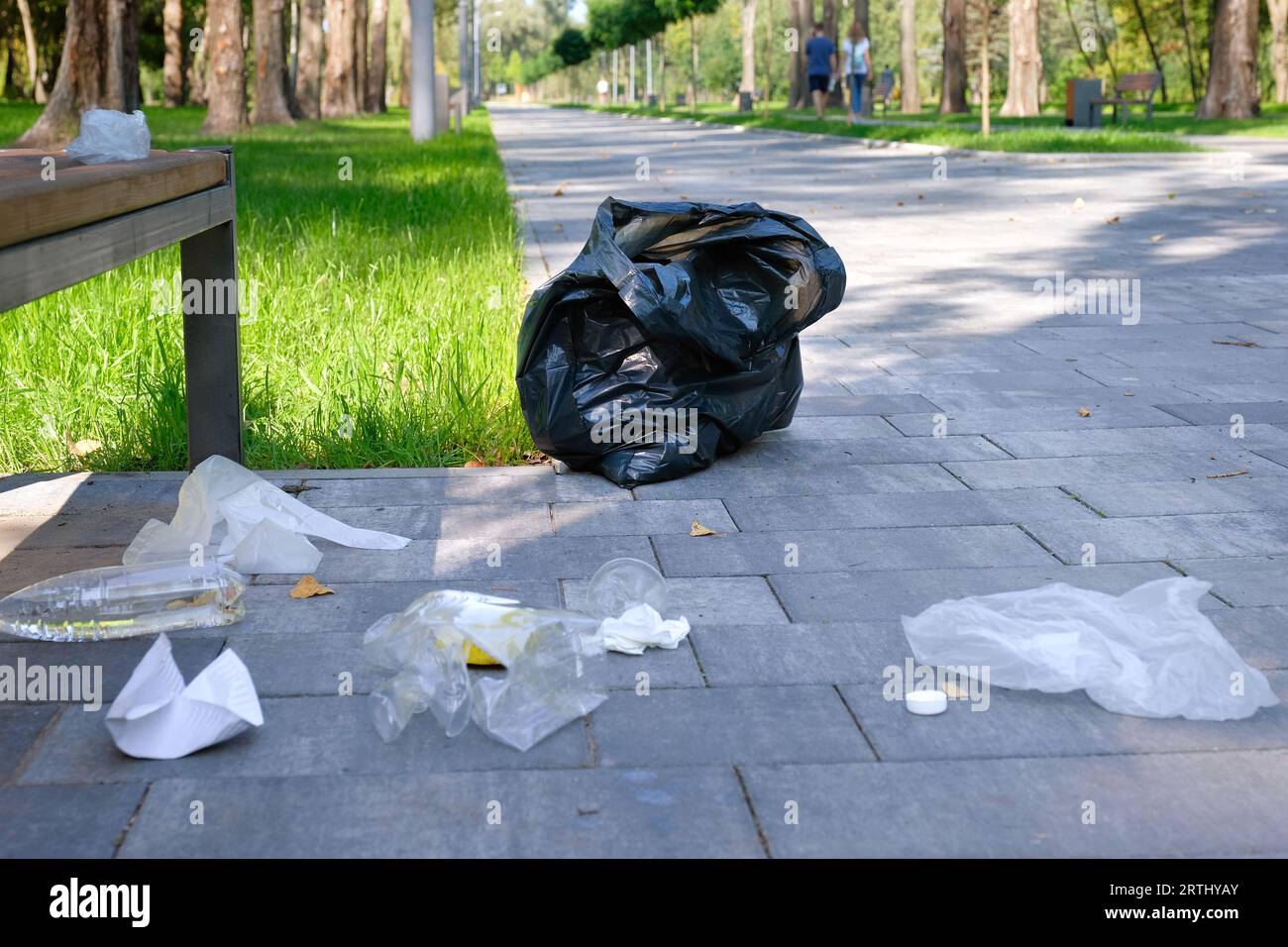 Garbage from plastic bottles, bags, paper, in the city park ...