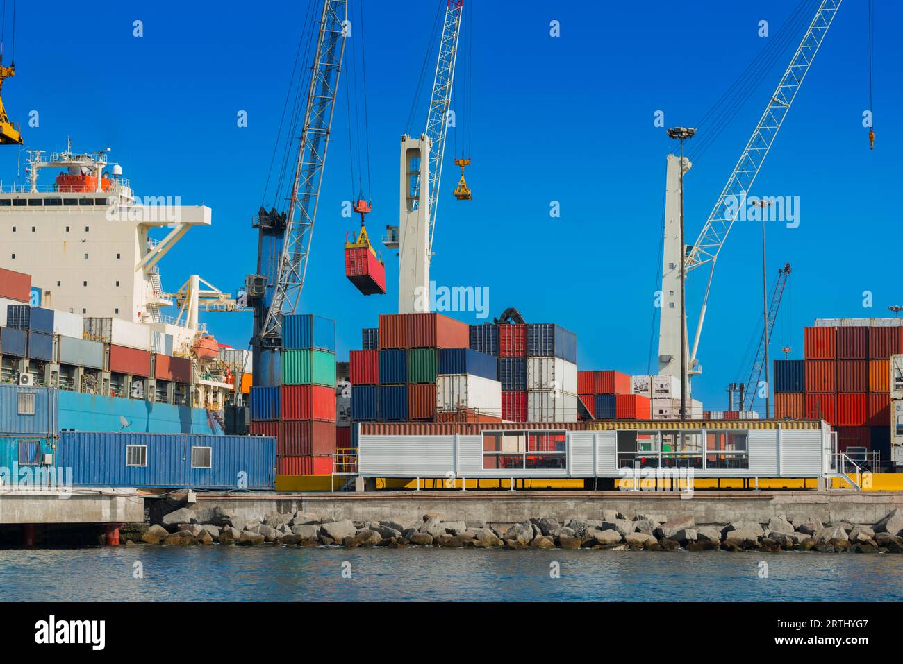 Containers being unloaded from a cargo ship at the port of Iquique in ...